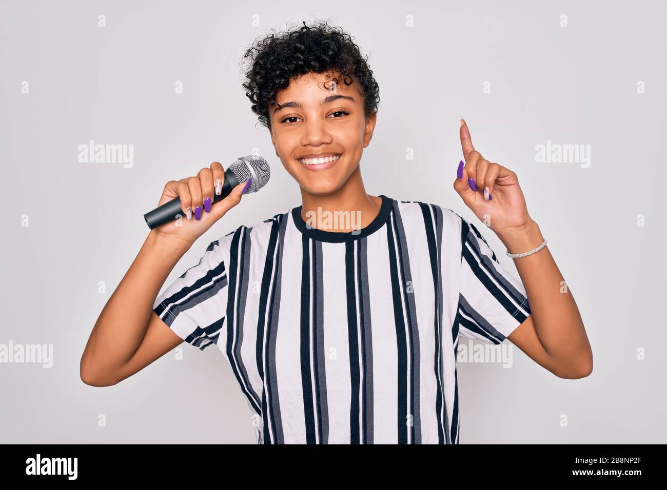 Beautiful african american afro singer woman singing using microphone ...