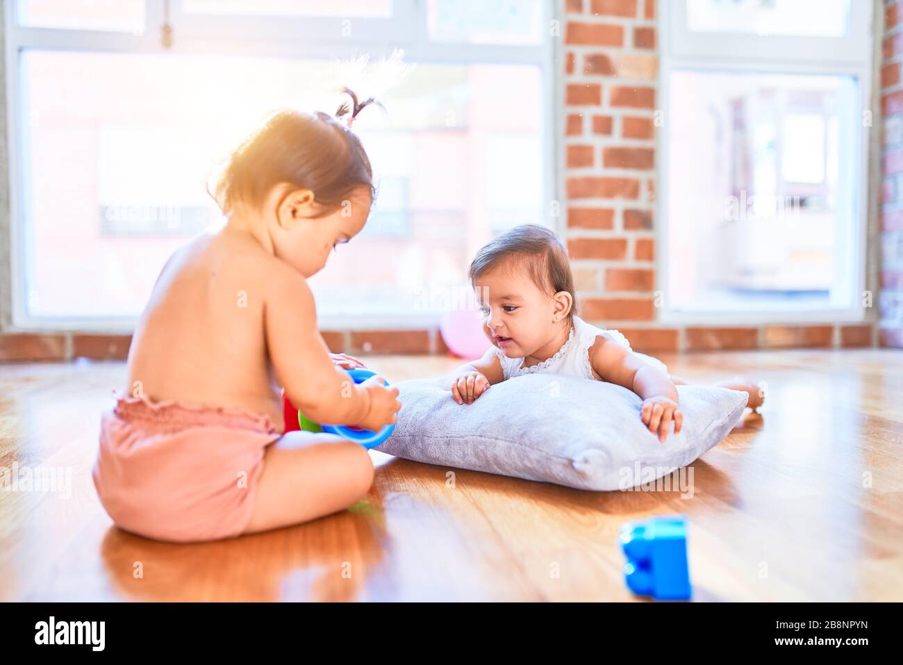 Beautiful infant happy girls playing together at home kindergarten ...