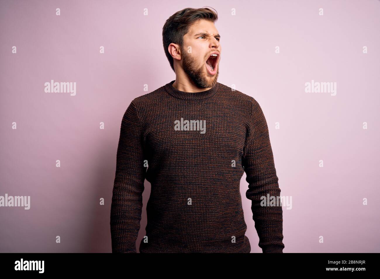 Young blond man with beard and blue eyes wearing casual sweater over ...