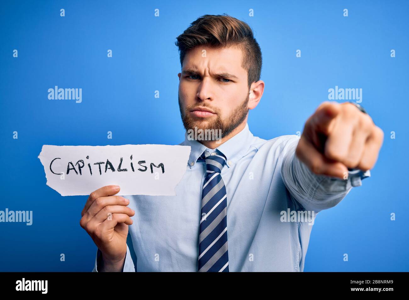 Young blond businessman with beard and blue eyes holding paper with ...