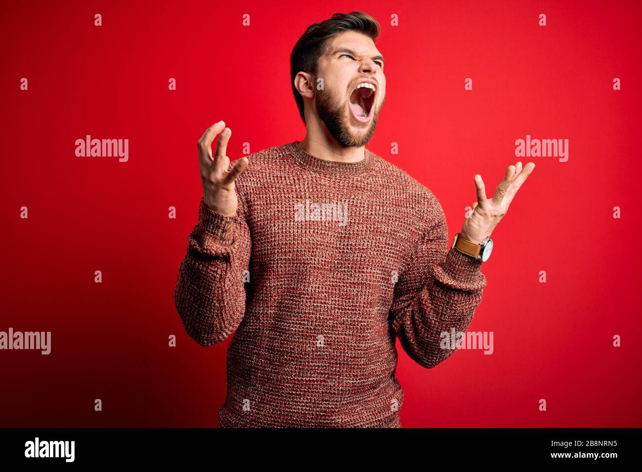 Young blond man with beard and blue eyes wearing casual sweater over ...