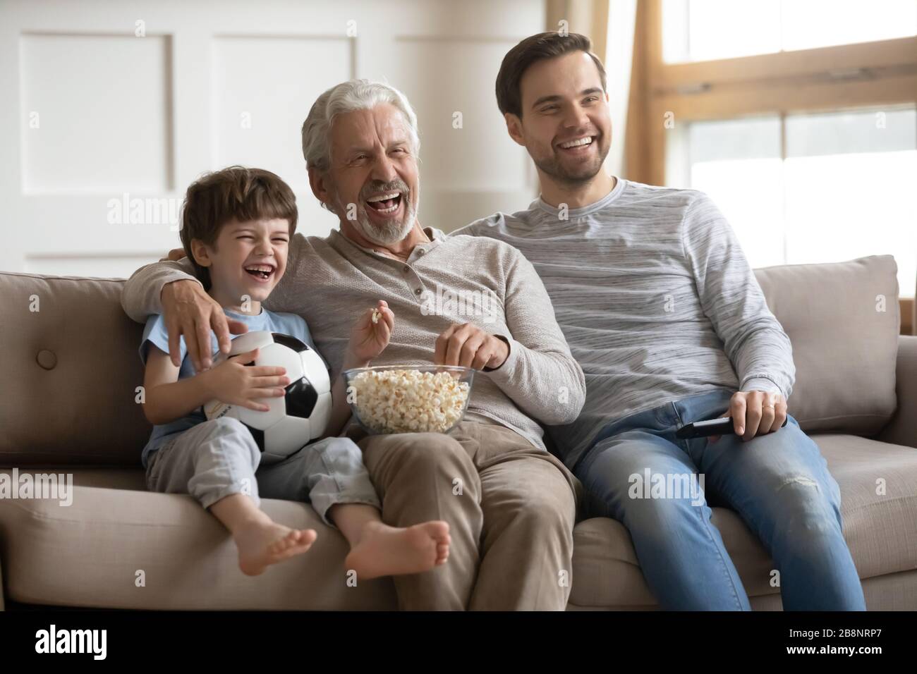 Three generations family watching tv hi-res stock photography and ...