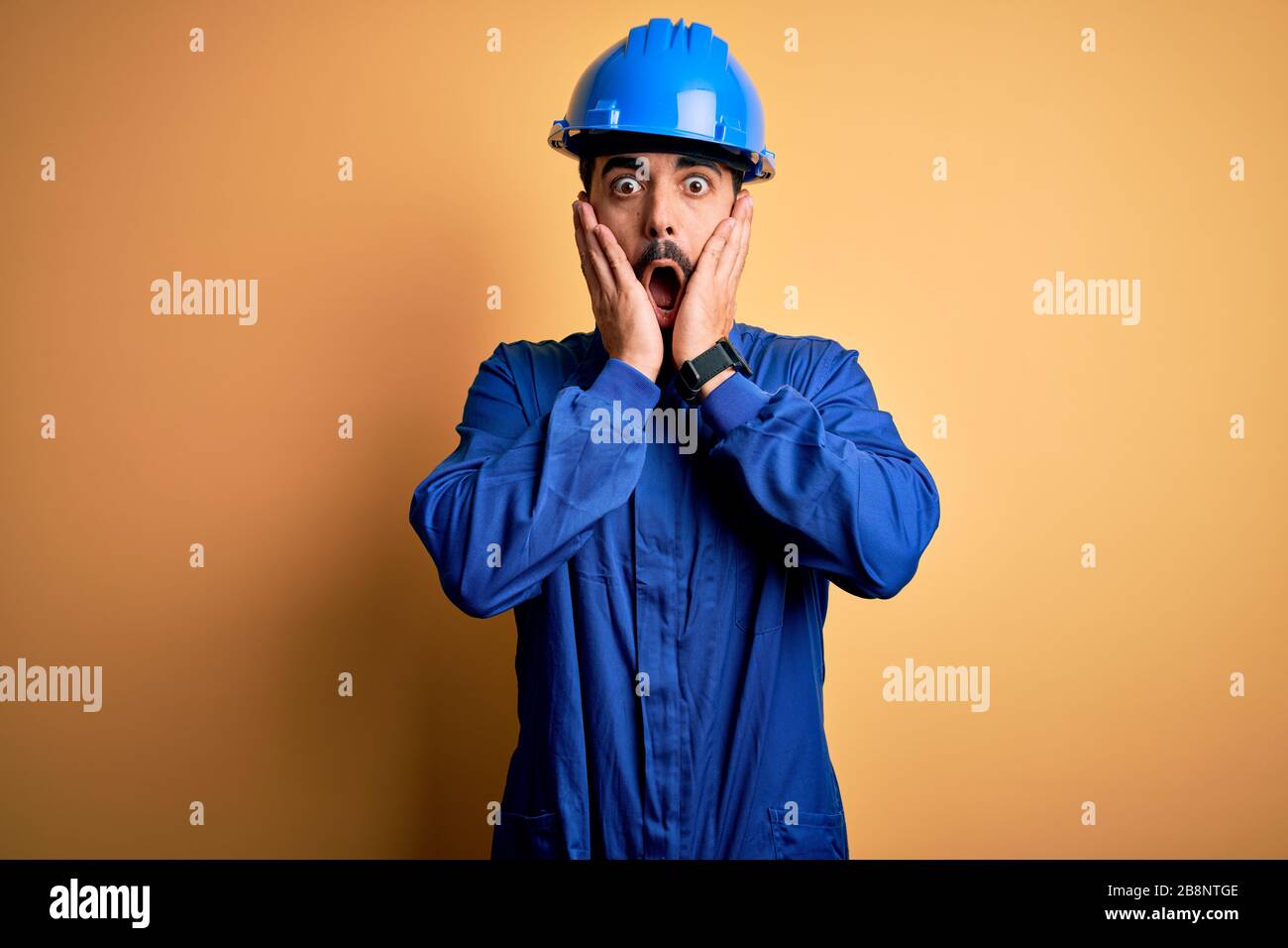 Mechanic man with beard wearing blue uniform and safety helmet over ...
