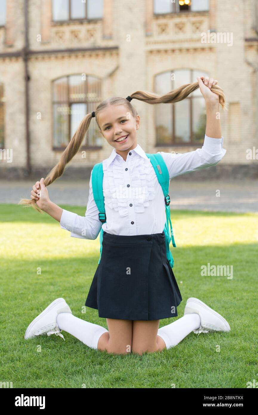 Long and healthy. Happy schoolchild hold long blond hair. Adorable ...