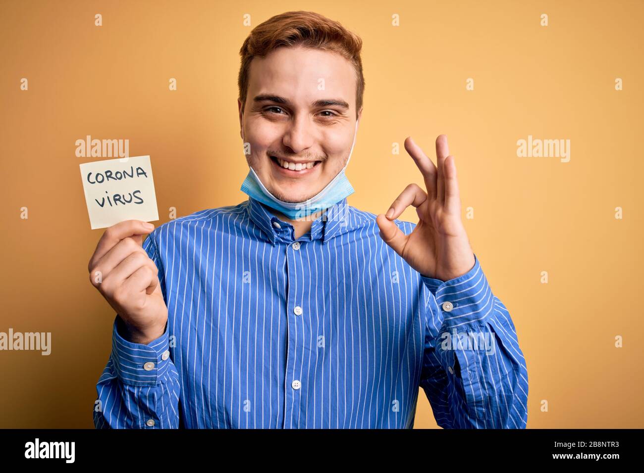 Young man wearing medical security mas holding paper note reminder with ...