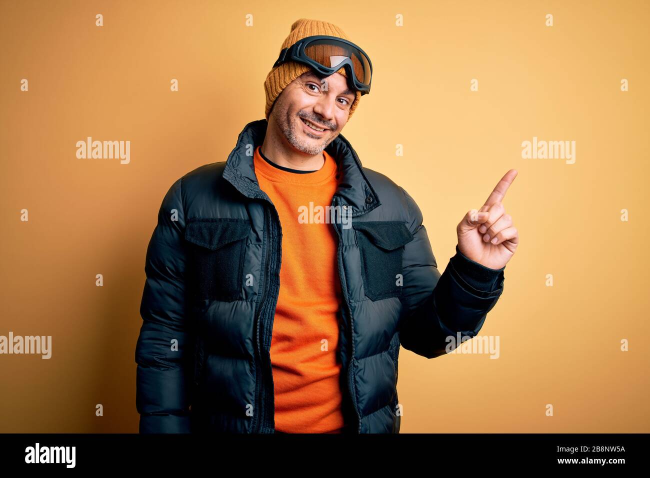 Young handsome skier man skiing wearing snow sportswear using ski ...
