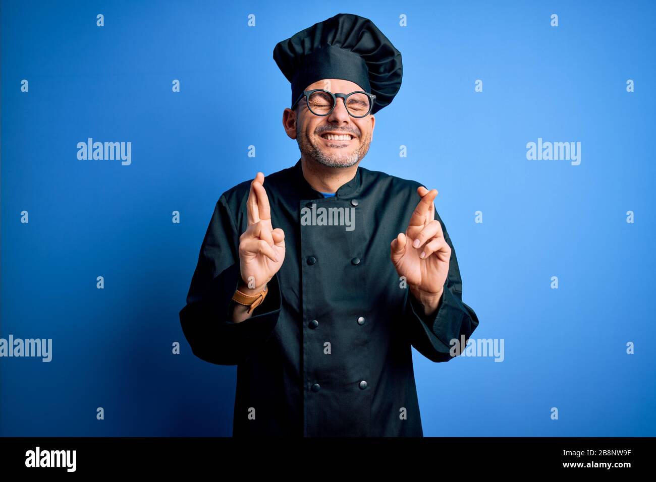 Young handsome chef man wearing cooker uniform and hat over isolated ...