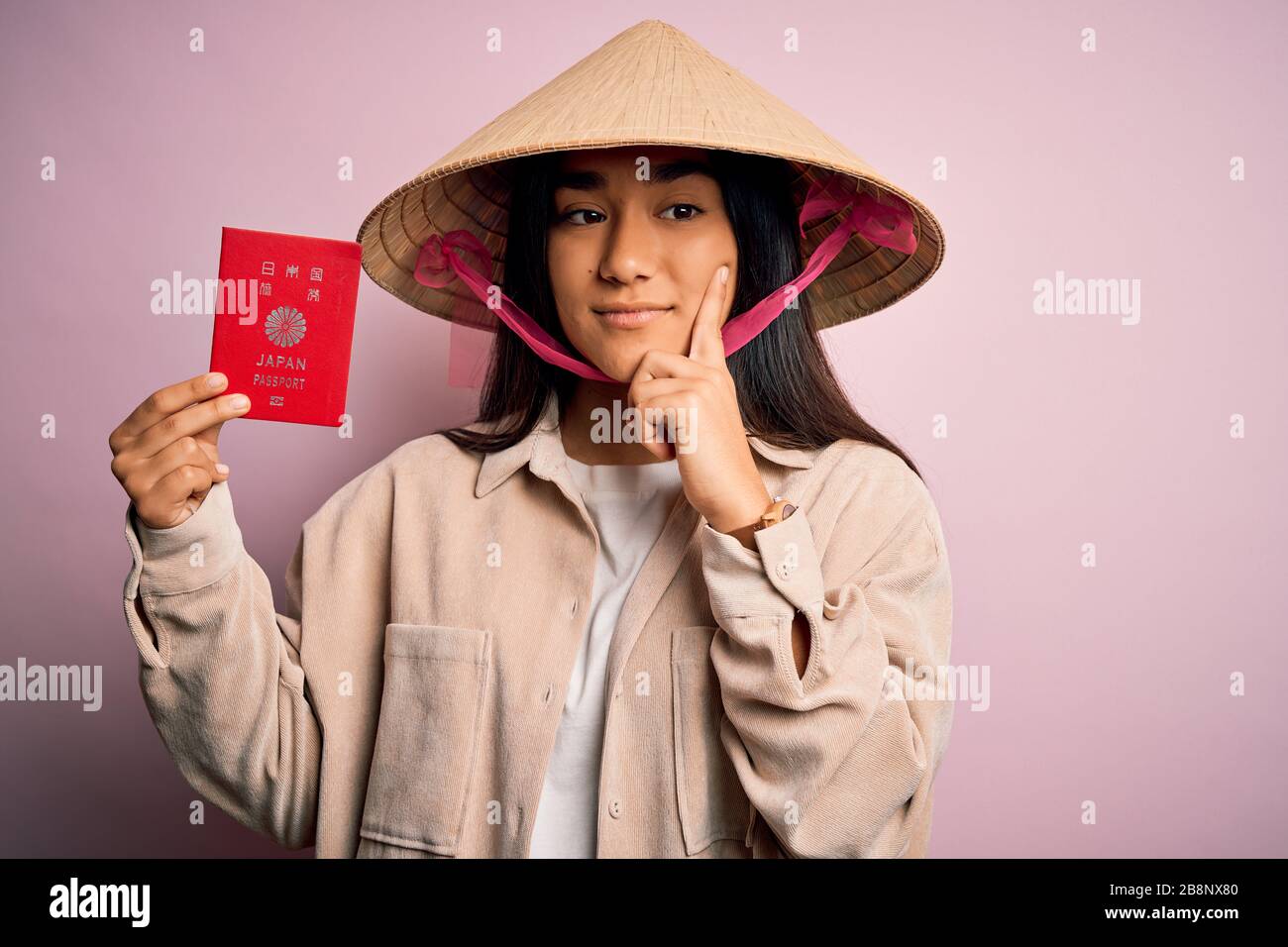 Young thai woman wearing traditional conical asian hat holding japan ...