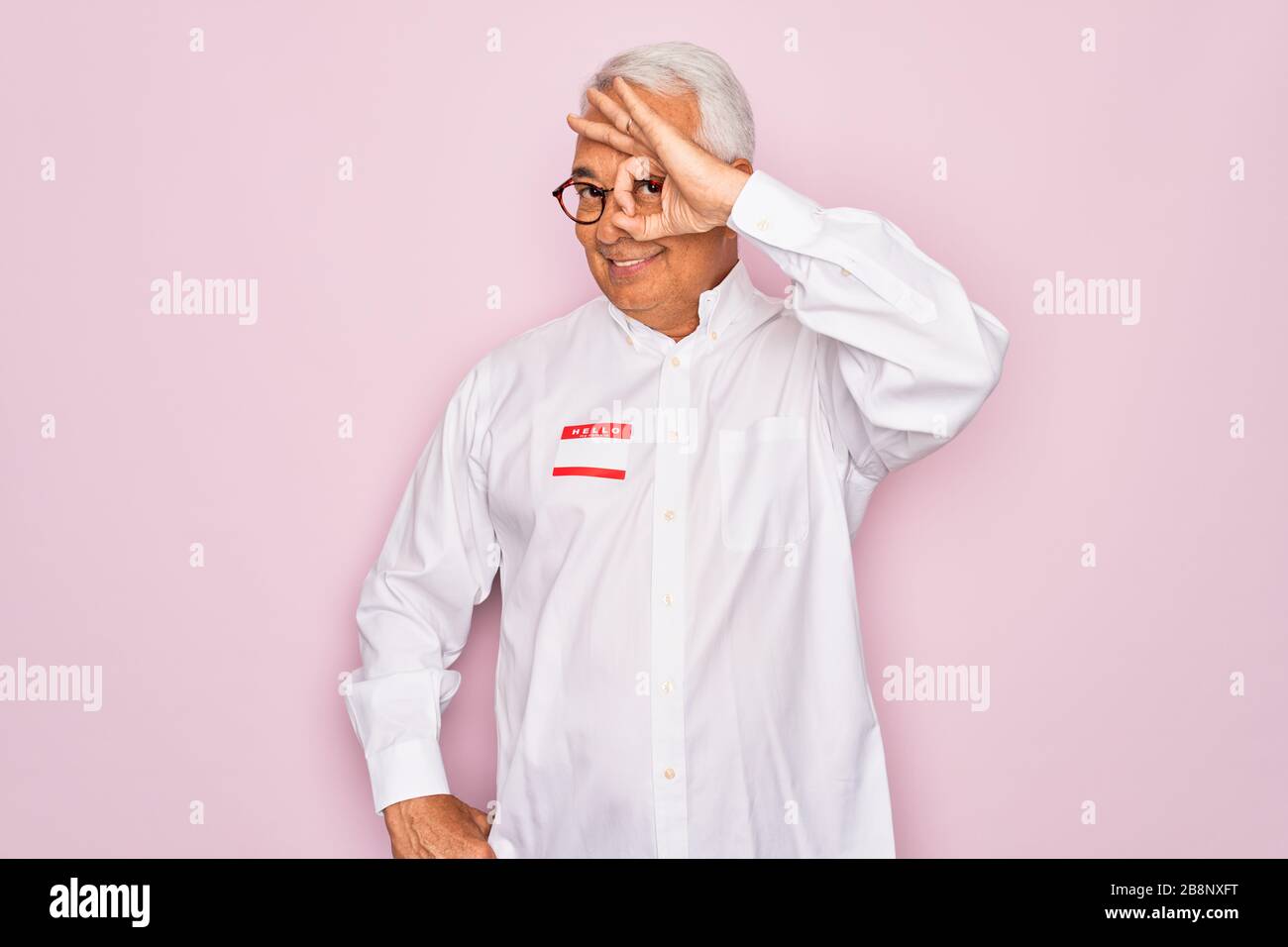 Middle age senior grey-haired man wearing hello my name is introduction ...