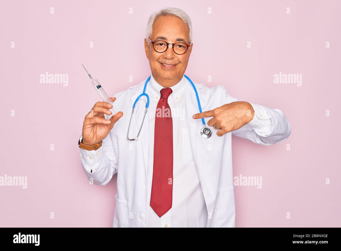 Middle age senior grey-haired doctor man holding medicine needle ...
