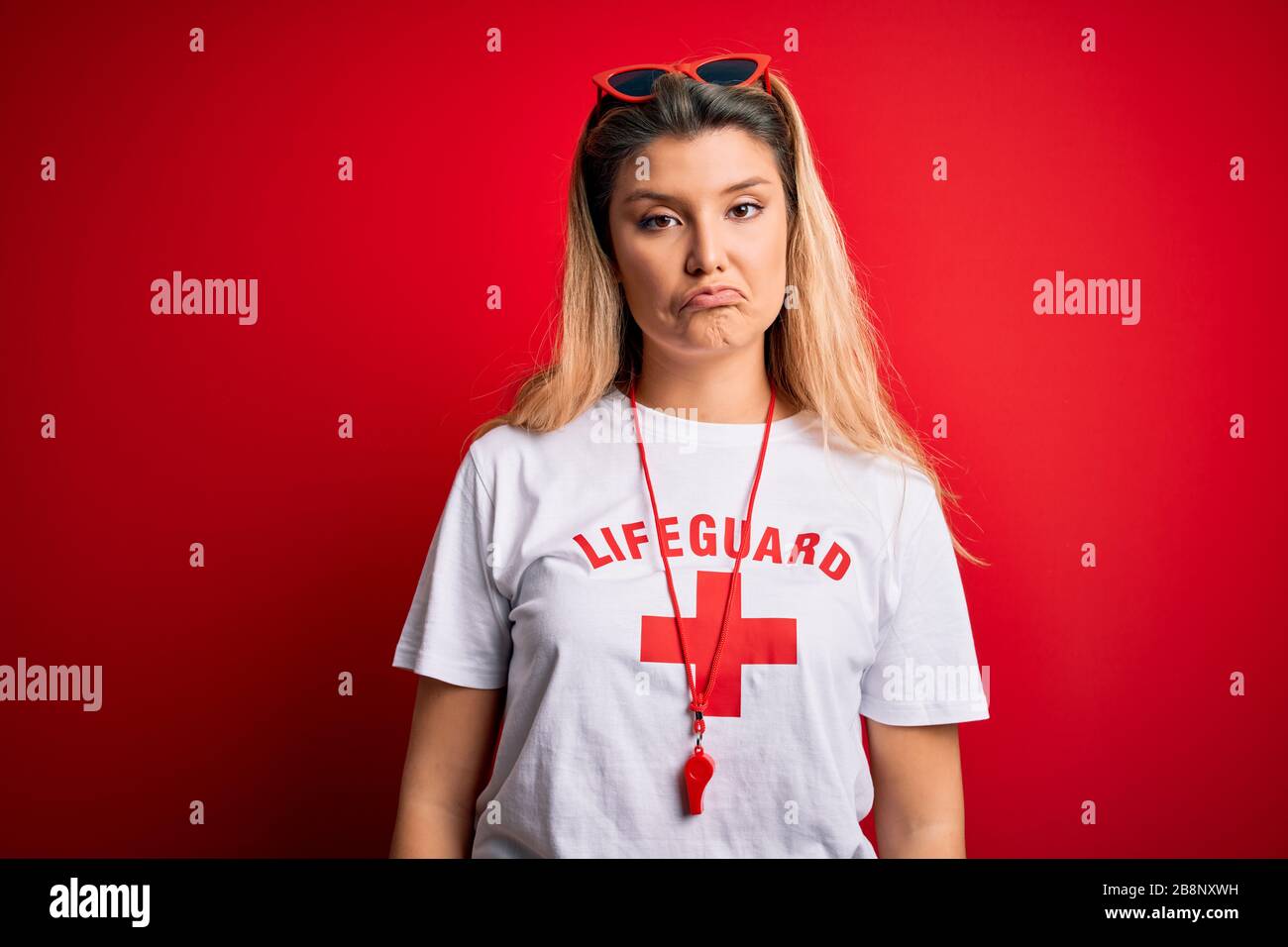 Young beautiful blonde lifeguard woman wearing t-shirt with red cross ...