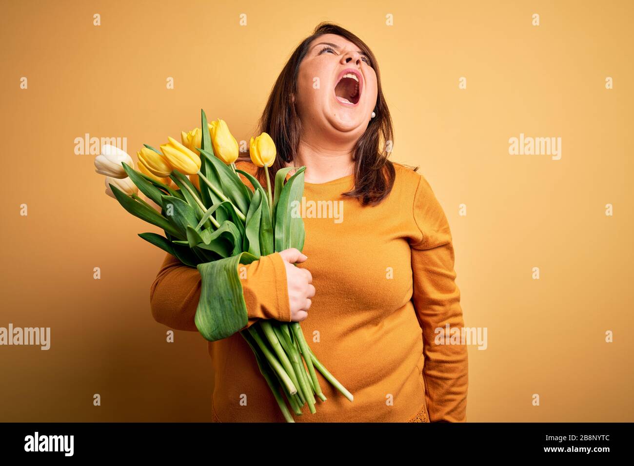 Beautiful plus size woman holding romantic bouquet of natural tulips ...