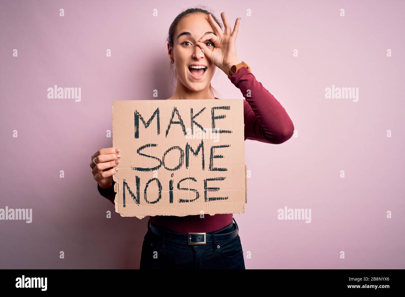 Beautiful activist woman holding banner with make some noise message ...