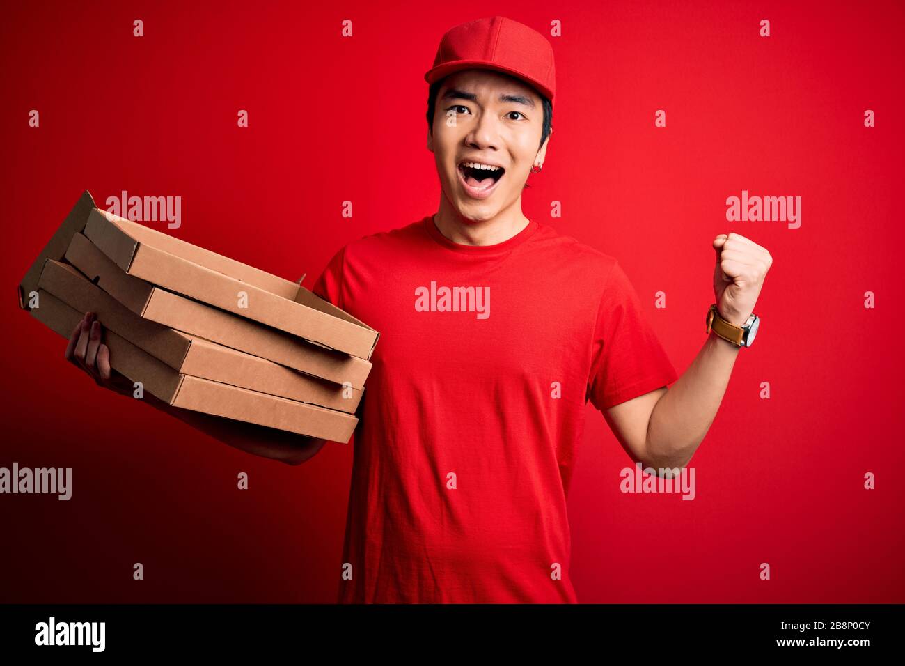 Young handsome chinese delivery man holding deliver boxes with Italian ...