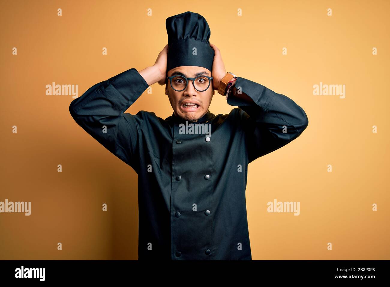 Young brazilian chef man wearing cooker uniform and hat over isolated ...