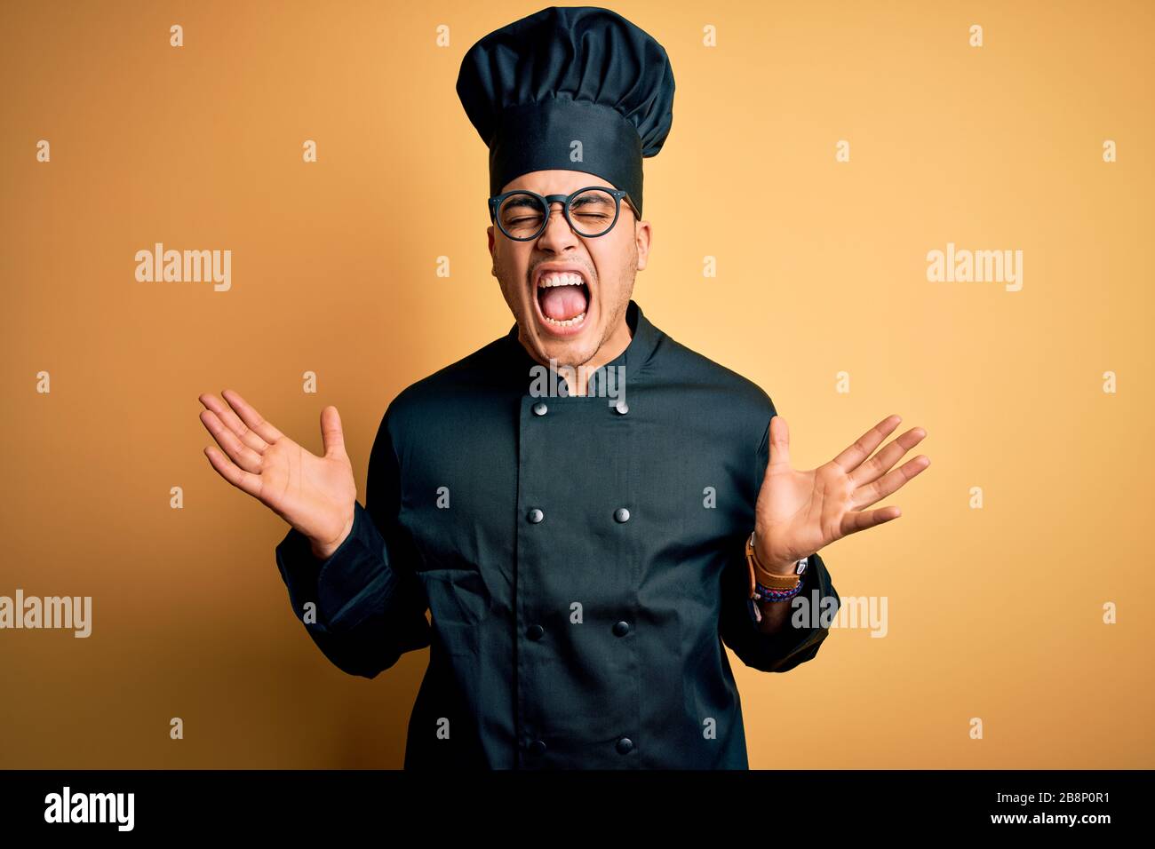 Young brazilian chef man wearing cooker uniform and hat over isolated ...