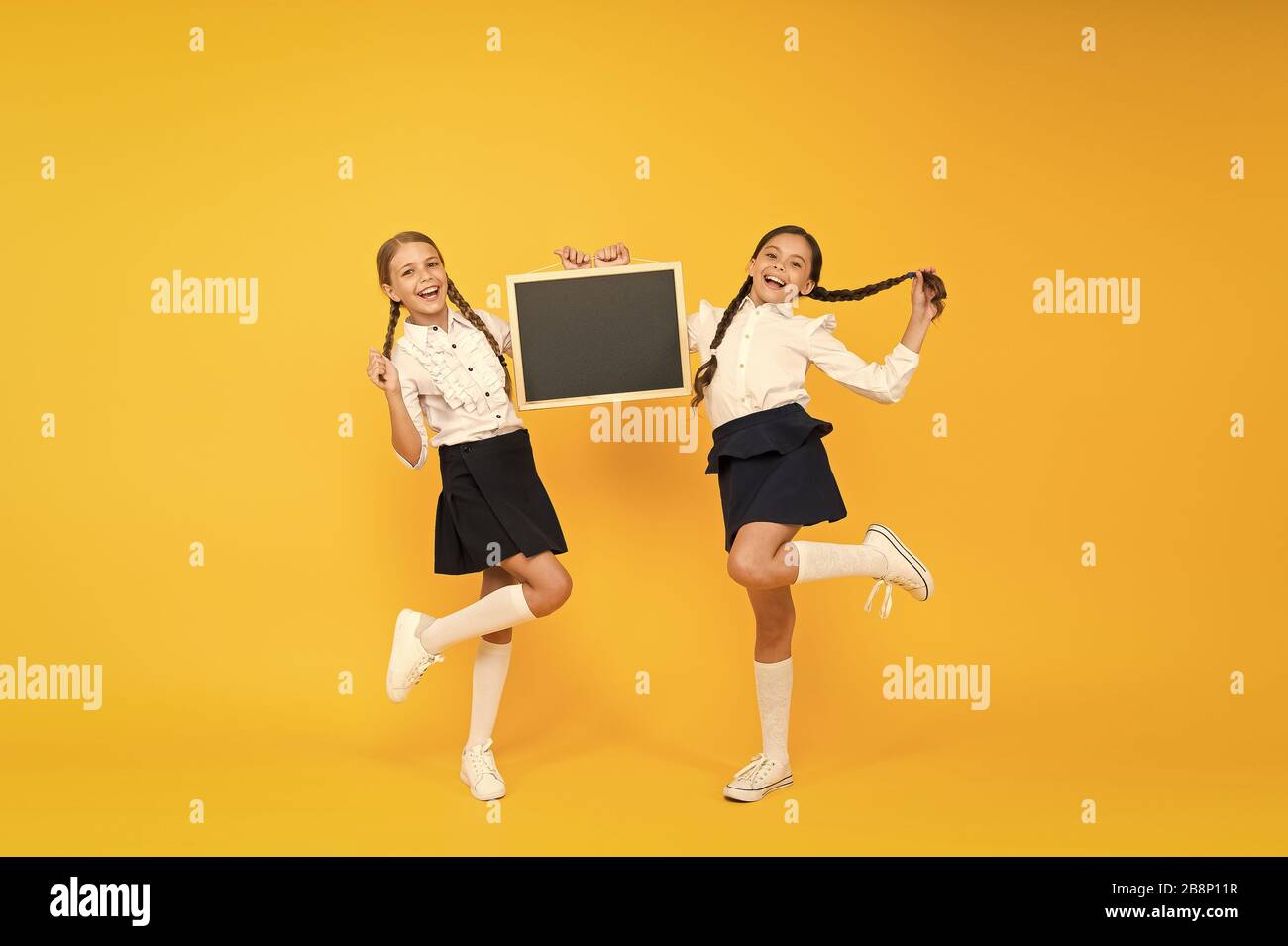 Back to school. Happy children holding school blackboard on yellow ...