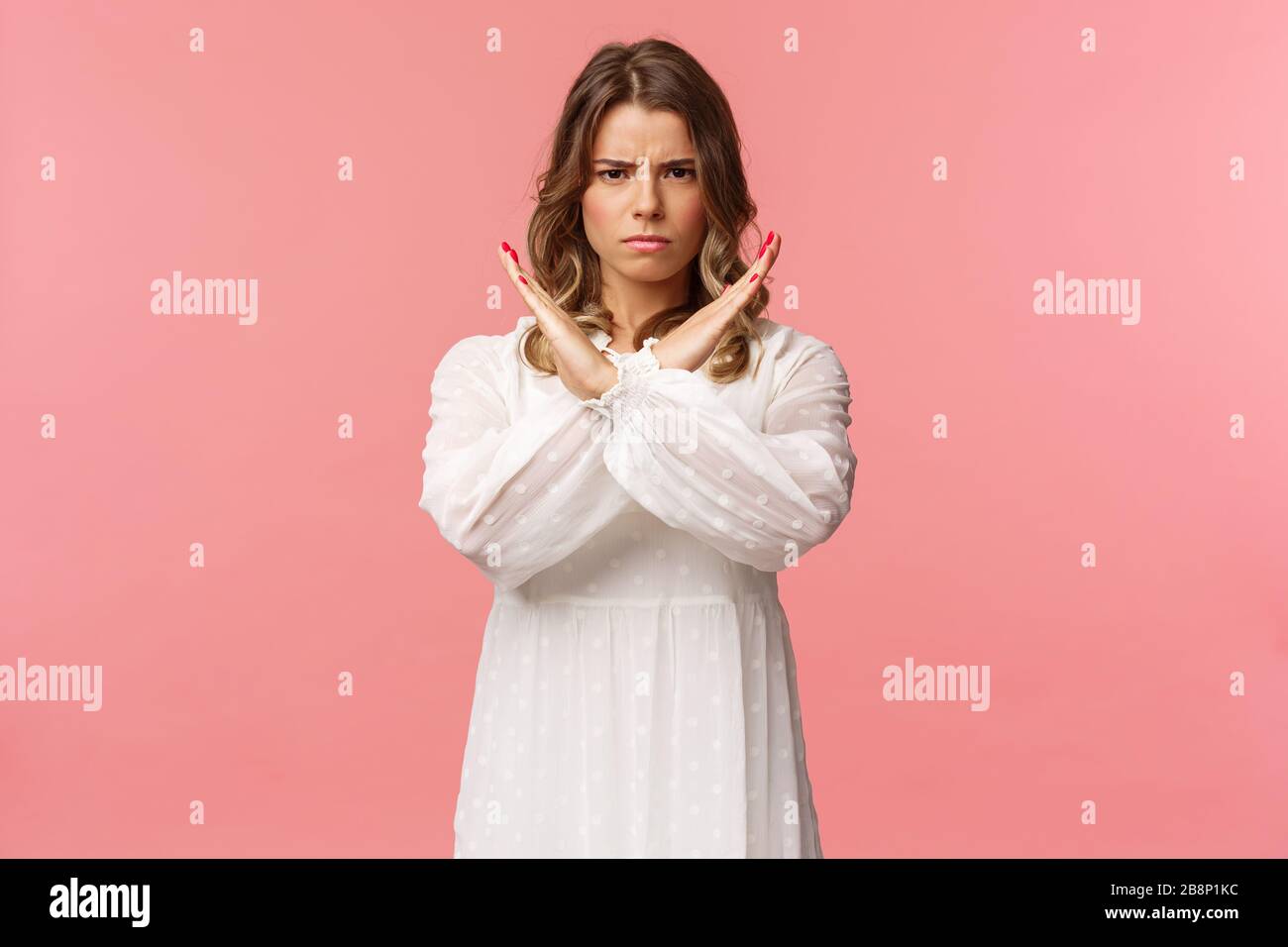 Portrait of serious-looking confident and displeased young blond woman ...