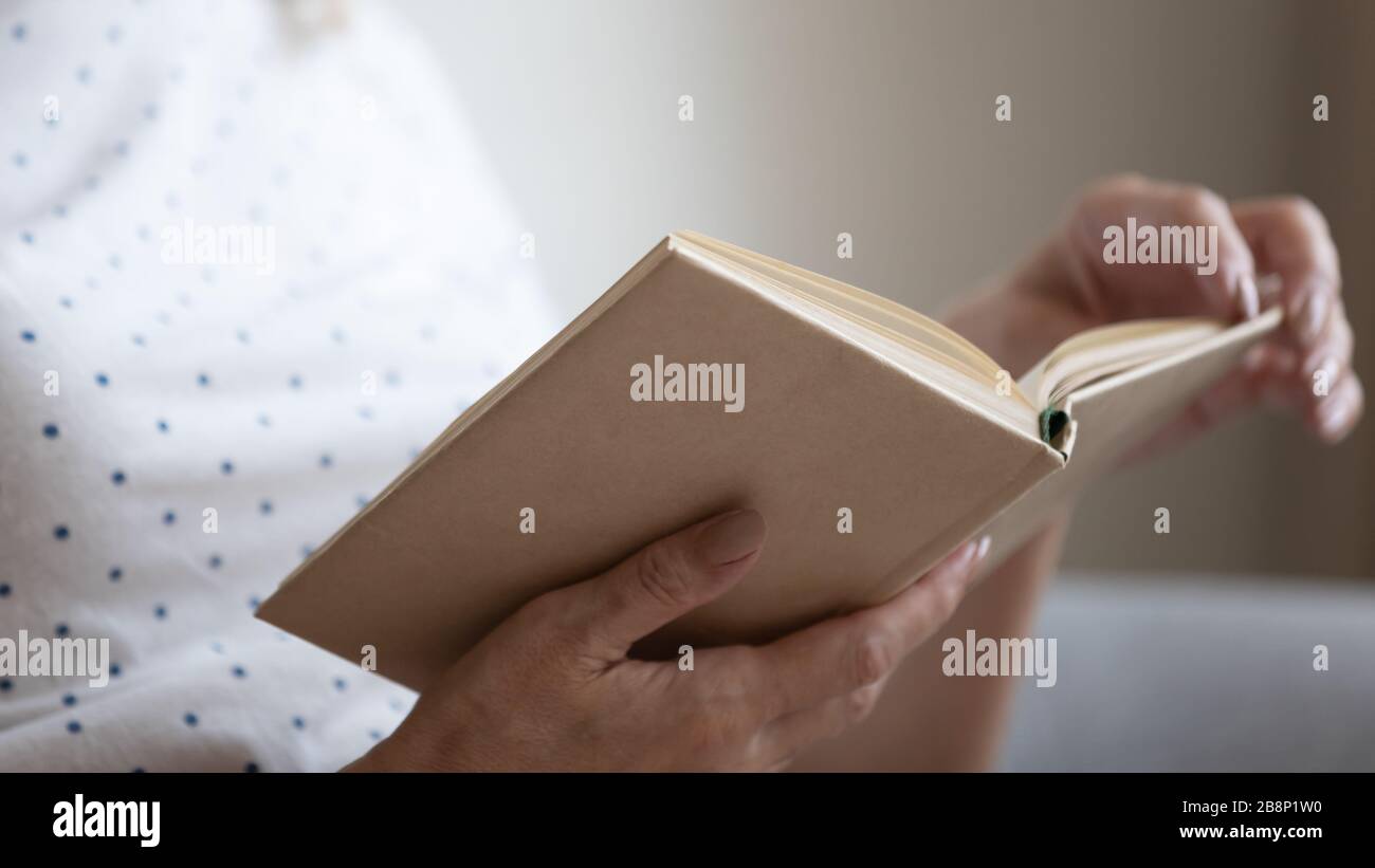 Close up female wrinkled hands holding paper book Stock Photo - Alamy