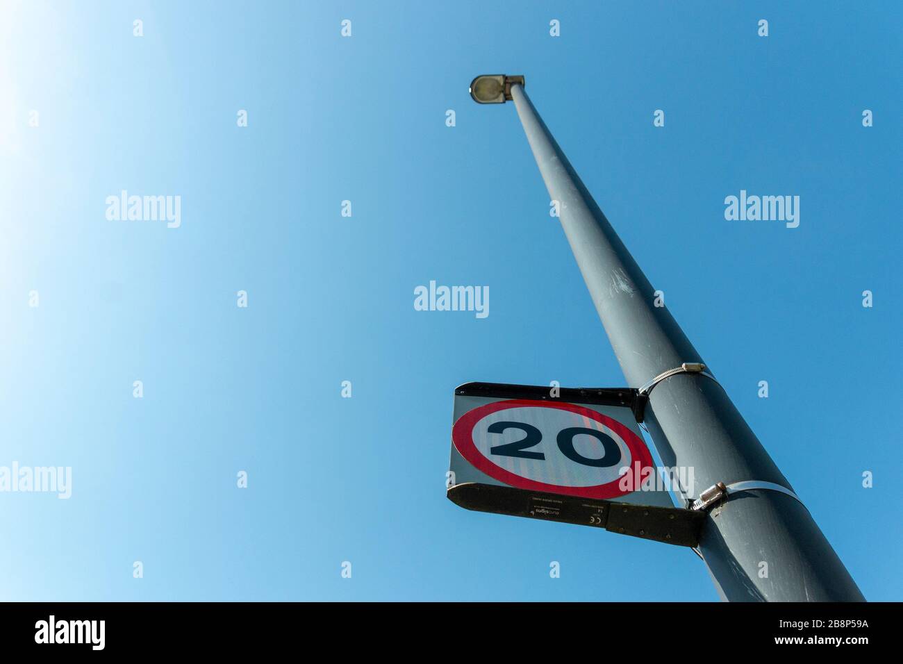 a close up view of a light post with a speed limit on it Stock Photo ...