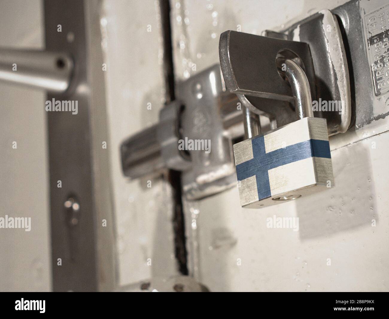 A bolted door secured by a padlock with the national flag of Finland on ...