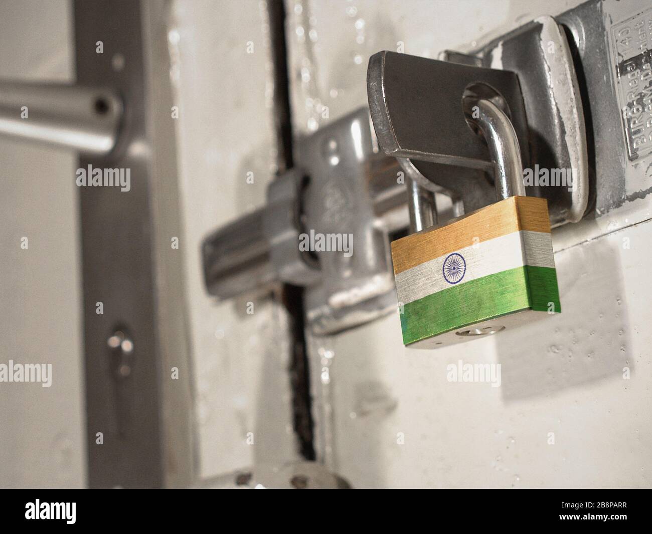 A bolted door secured by a padlock with the national flag of India on ...