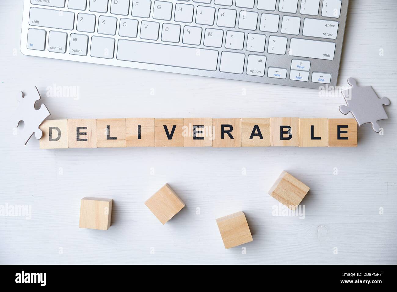 Modern business buzzword - deliverable. Top view on keyboard and puzzle ...