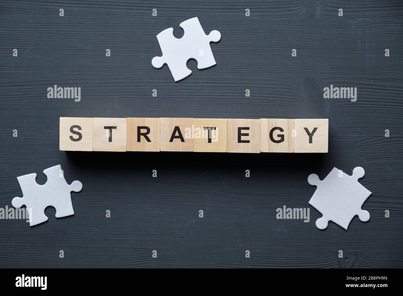 Modern business buzzword - strategy. Top view on a board with a puzzle ...