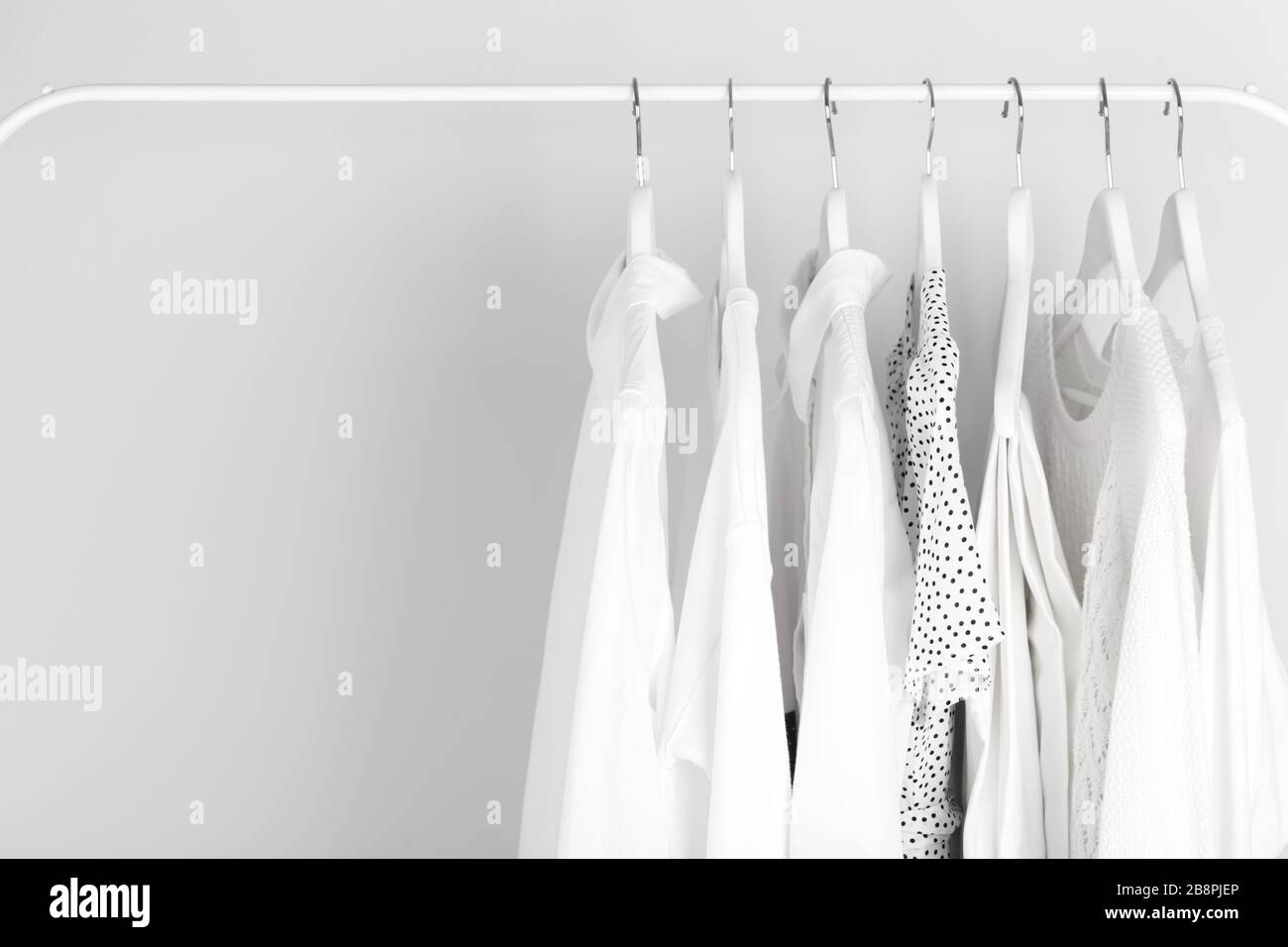 White spring female clothes hanging on a rack in a shop Stock Photo - Alamy