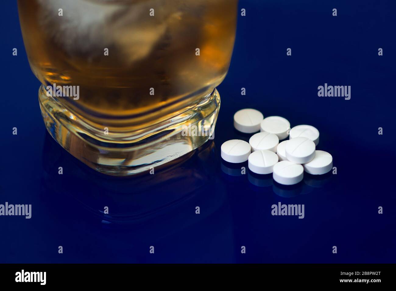 Tumbler of alcoholic beverage and ice with white prescription ...