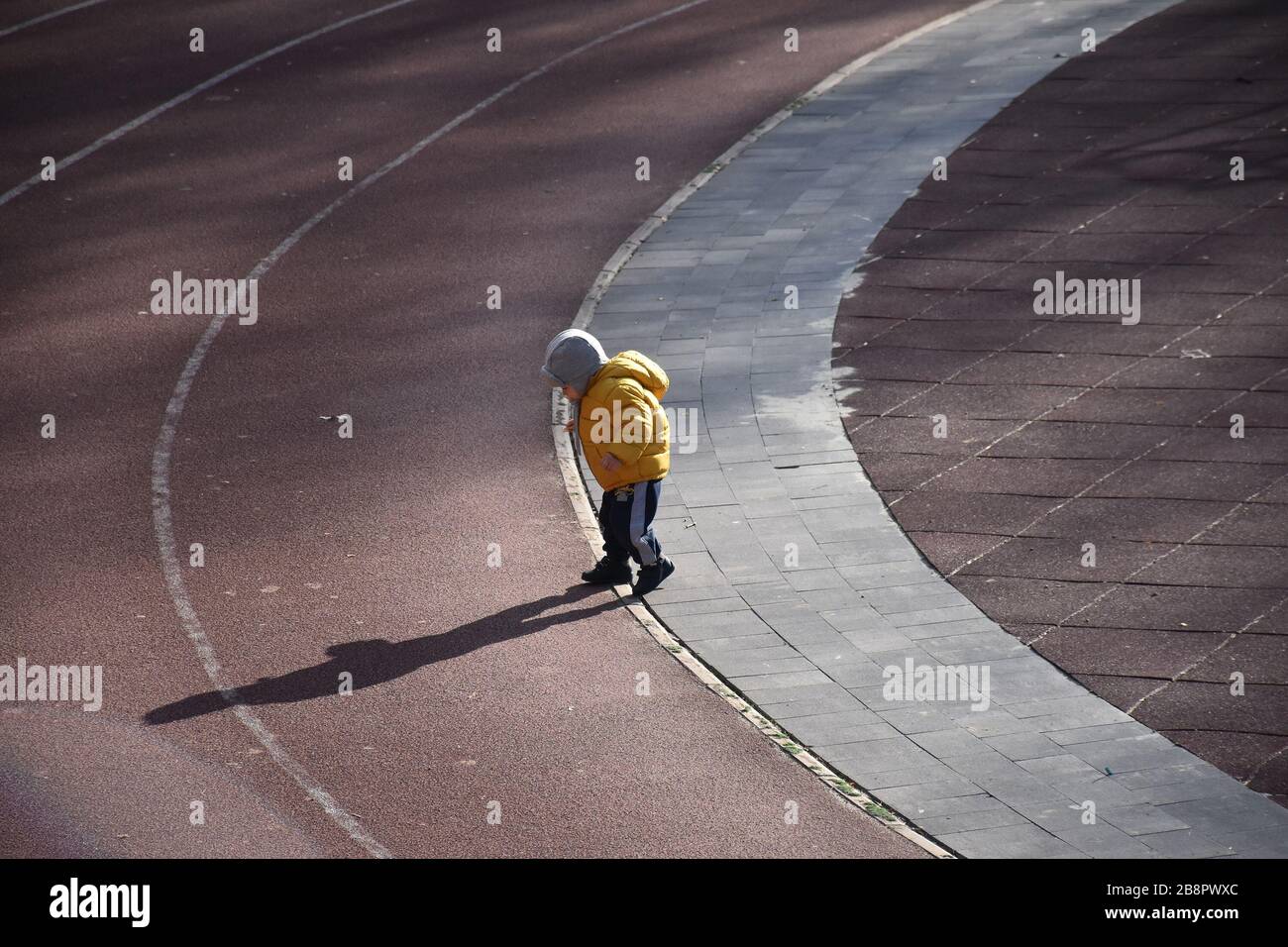 Little boy on a circular sports track Stock Photo - Alamy