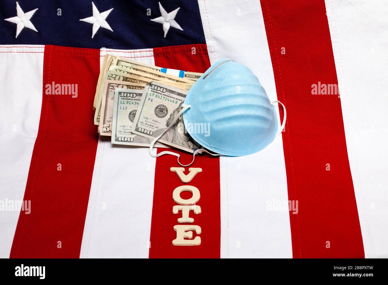 Respirator mask with cash money and the words vote in front of the ...