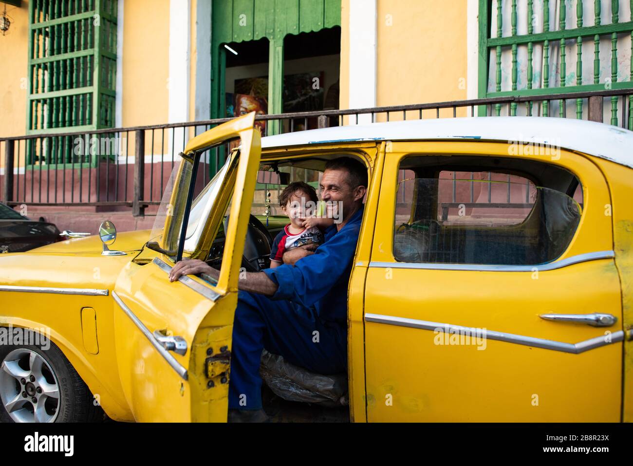 Father with child in yellow car #1, Havana, Cuba Stock Photo - Alamy