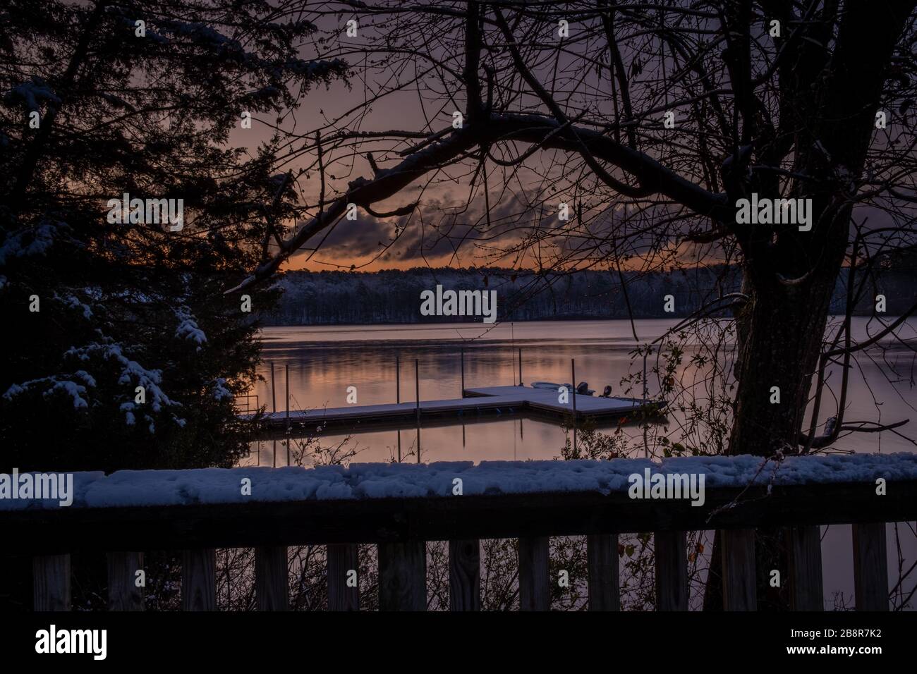View of the snow-covered pier during early morning twilight at Lake ...