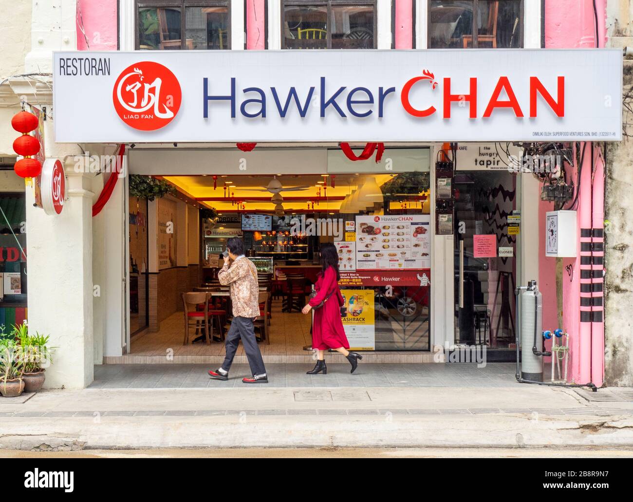 Couple walking past Hawker Chan restaurant shophouse on Jalan Petaling ...