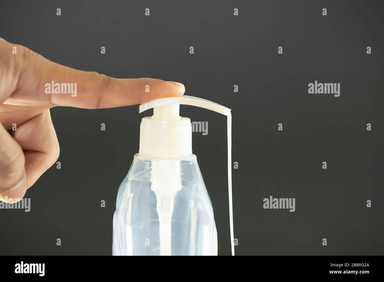A hand pushing the button of the liquid soap bottle. Hand sanitizer ...
