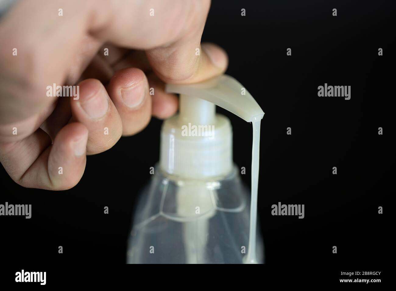 A hand pushing the button of the liquid soap bottle. Hand sanitizer ...