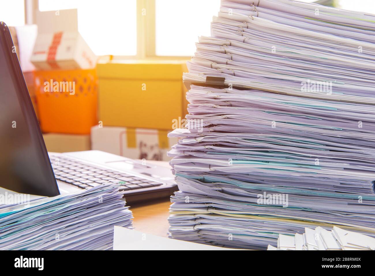 documents on desk stack up high waiting to be managed Stock Photo - Alamy
