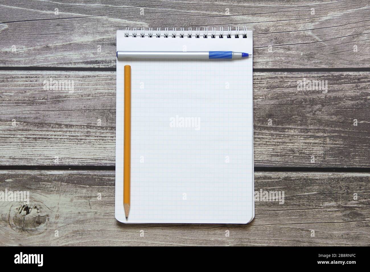 Notepad with a blank white sheet in a checker paper with ball pen and ...