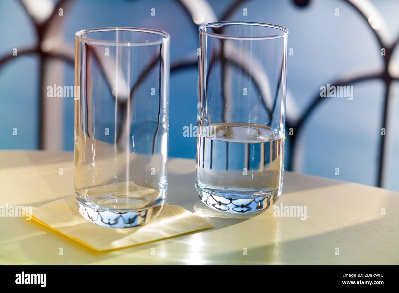 One empty and one half full glasses of water, outdoor close up Stock ...