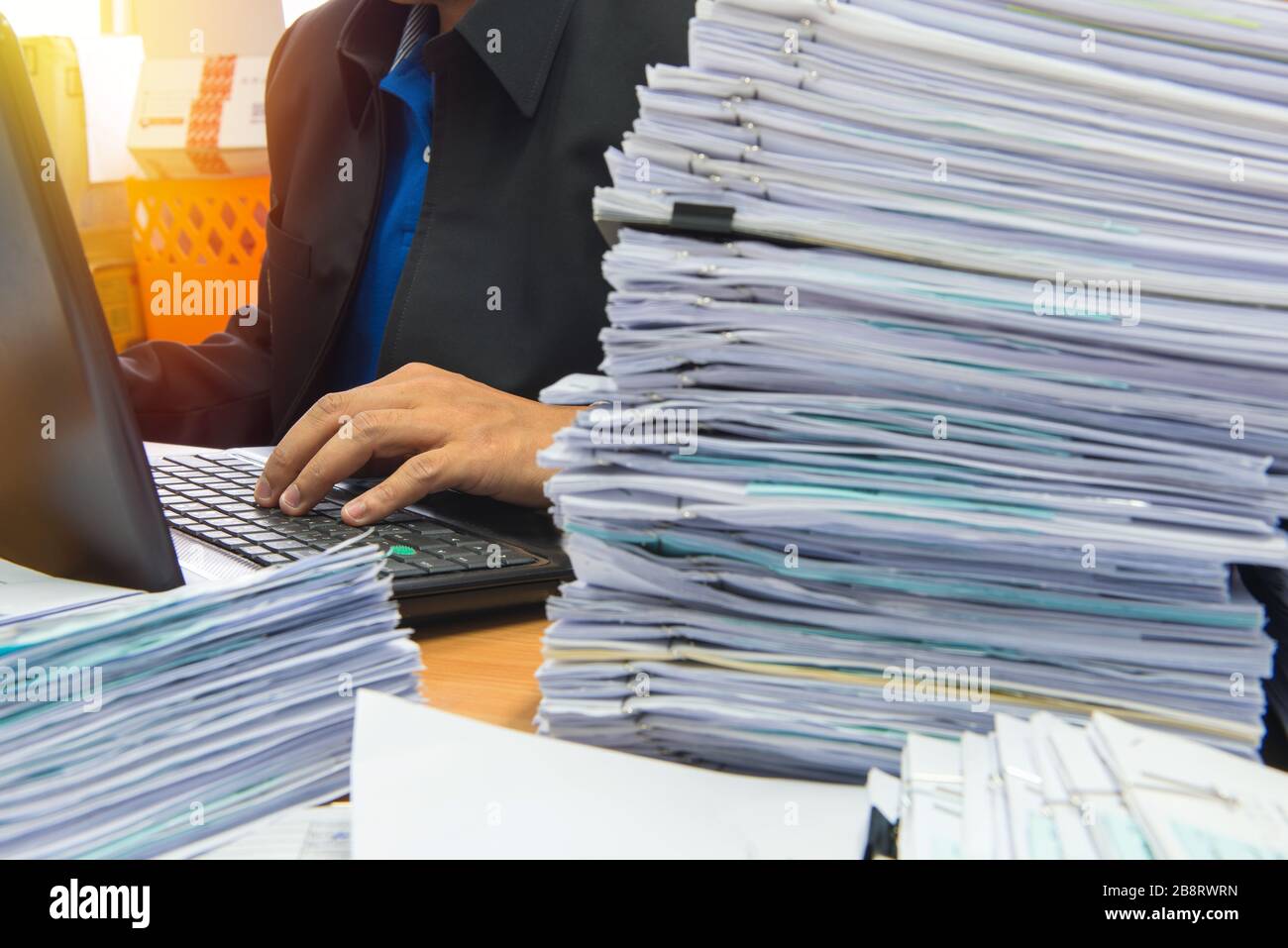 documents on desk stack up high waiting to be managed Stock Photo - Alamy