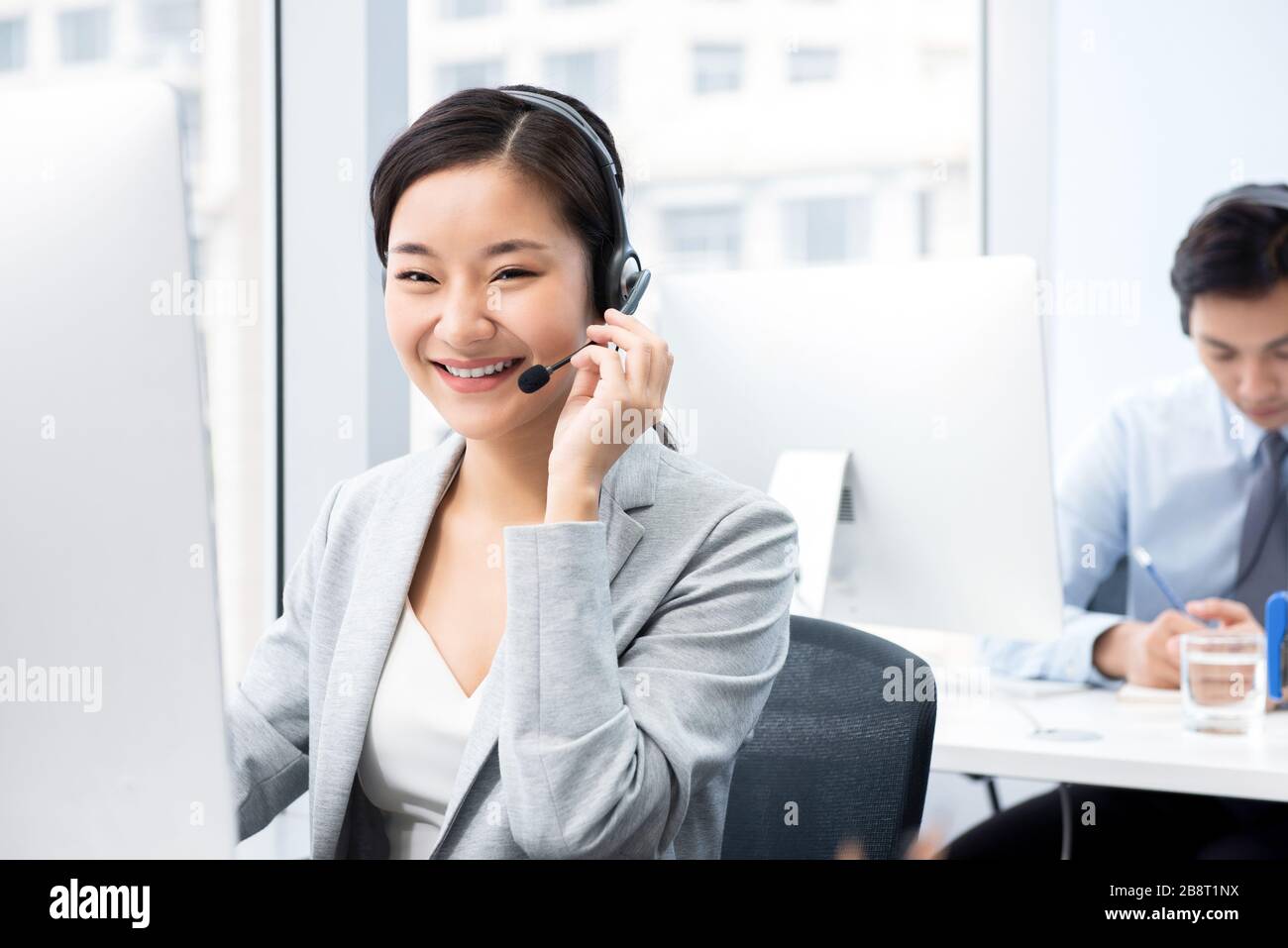 Smiling beautiful Asian woman working in call center office as a ...