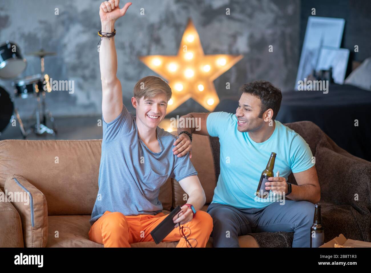 Male friends having beer together hi-res stock photography and images ...