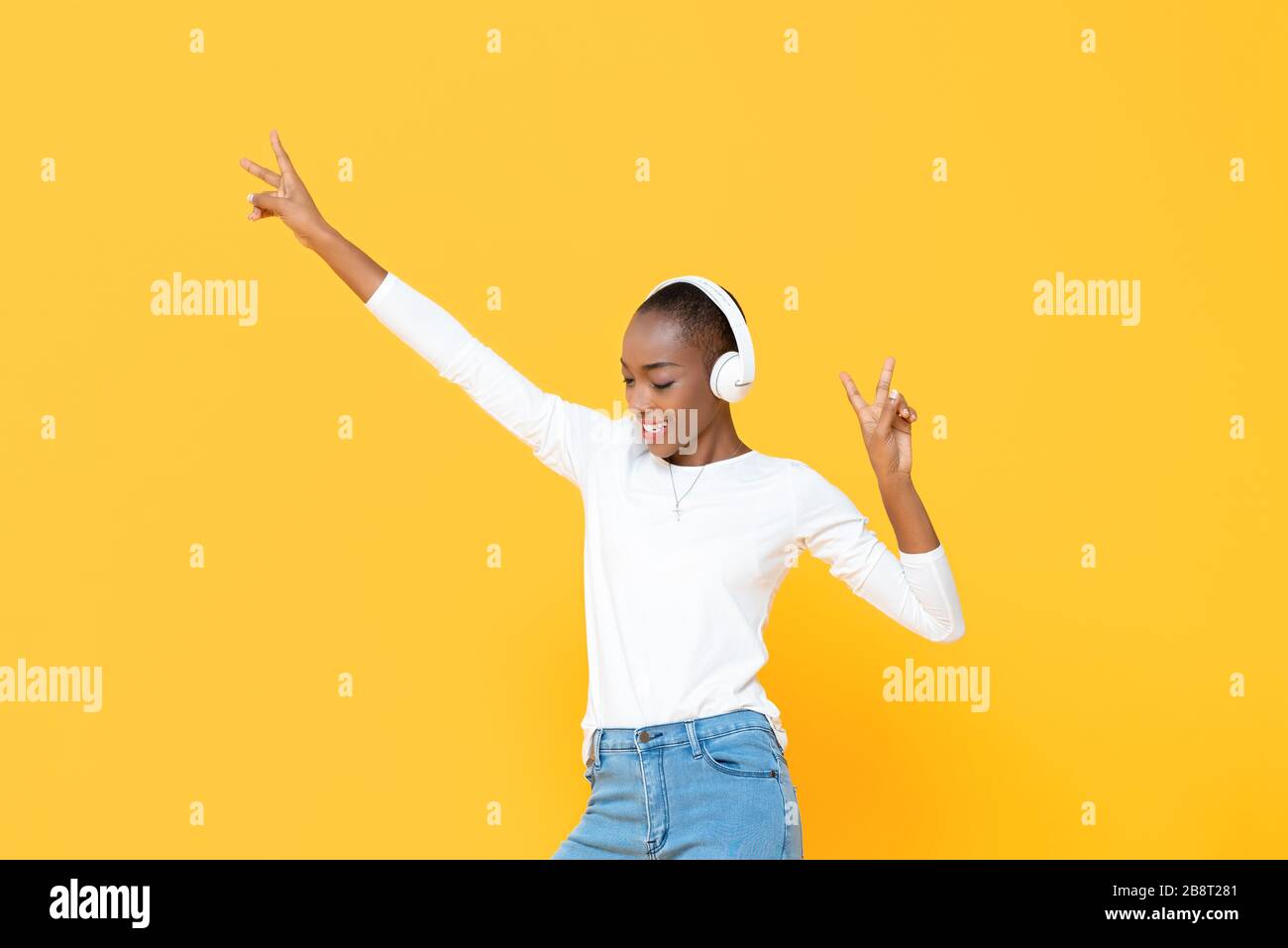 Happy African American woman listening to music on wireless headphone ...