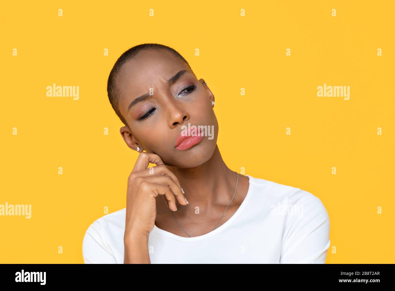 African-American woman feeling bored on yellow isolated studio ...