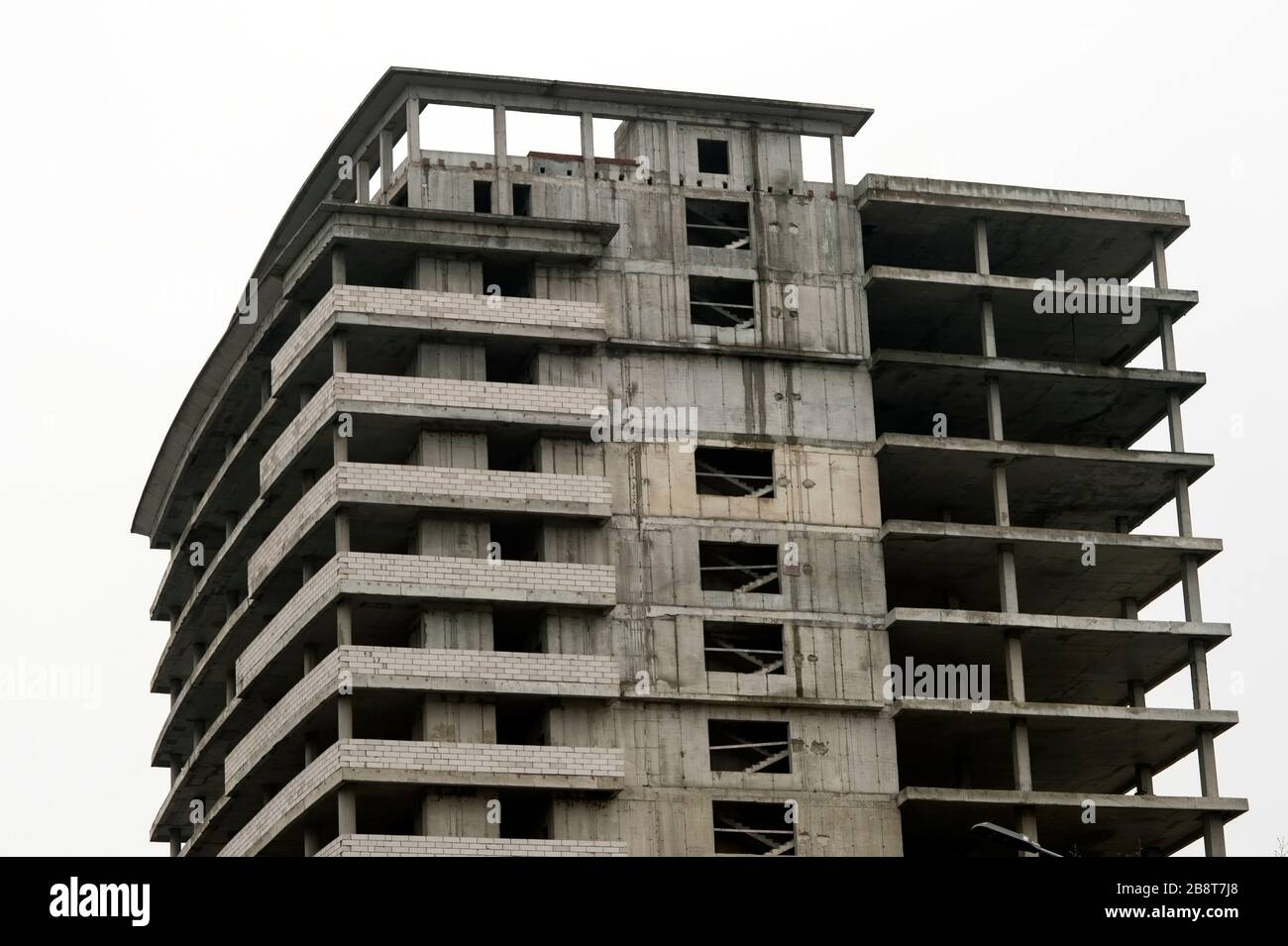 The upper part of a concrete grey high-rise building is partially ...