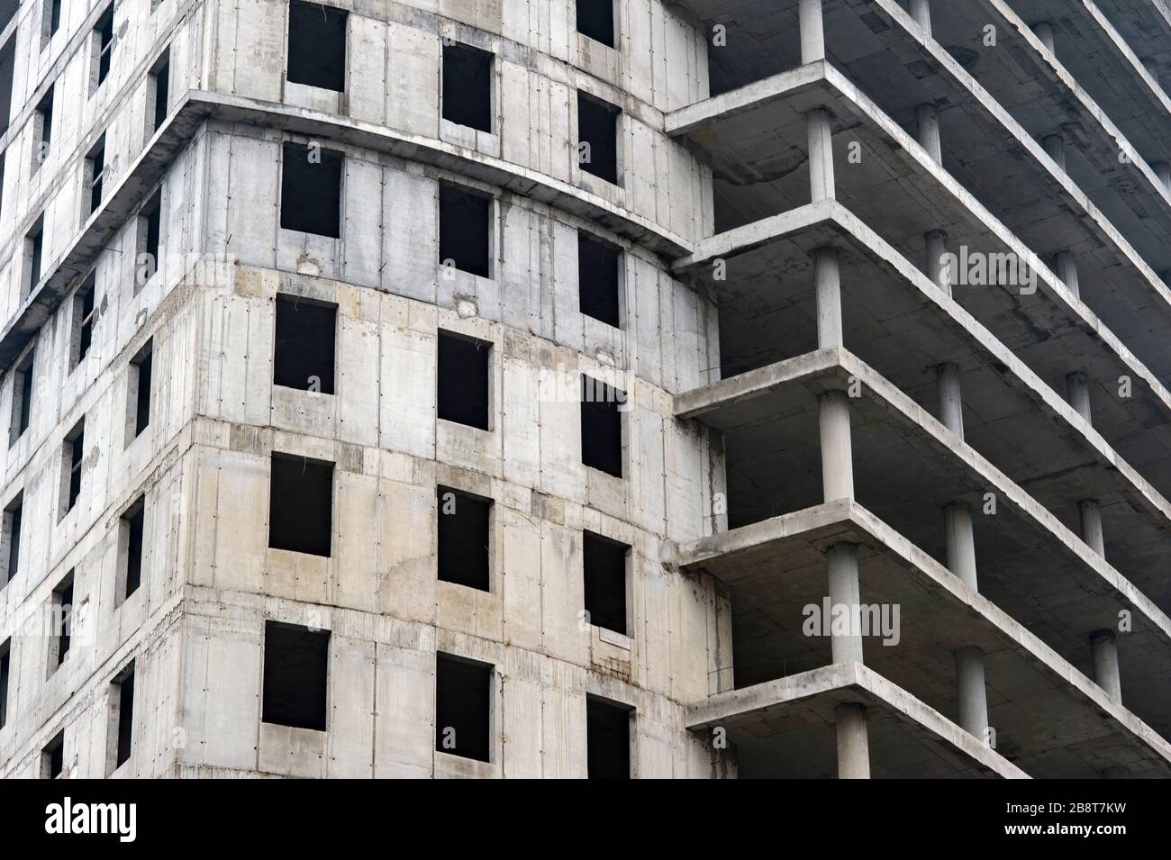 Concrete gray high-rise building close -up partially without external ...