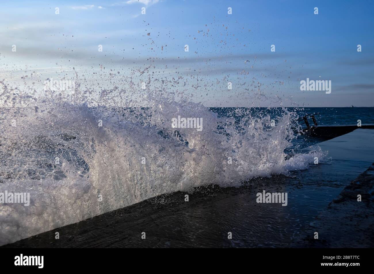 Bright sunset under the sea with waves splashes and stones Stock Photo ...