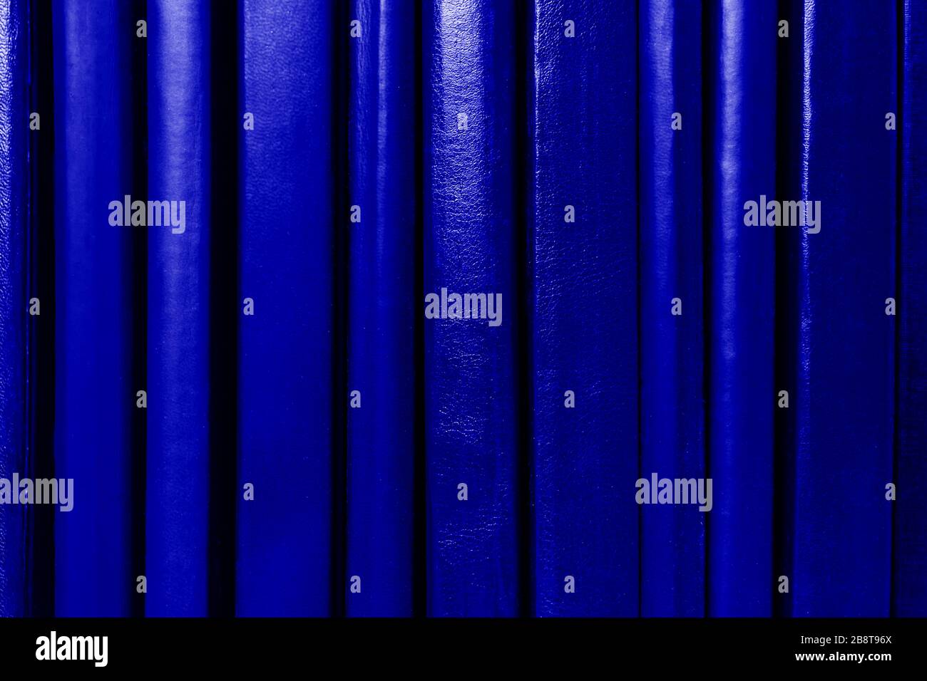 Dark blue book covers background. Books spines on shelf. Education and ...