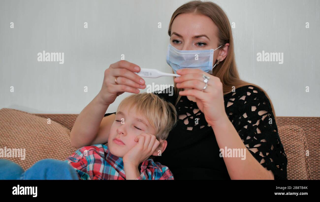 Son caring ill mom couch hi-res stock photography and images - Alamy